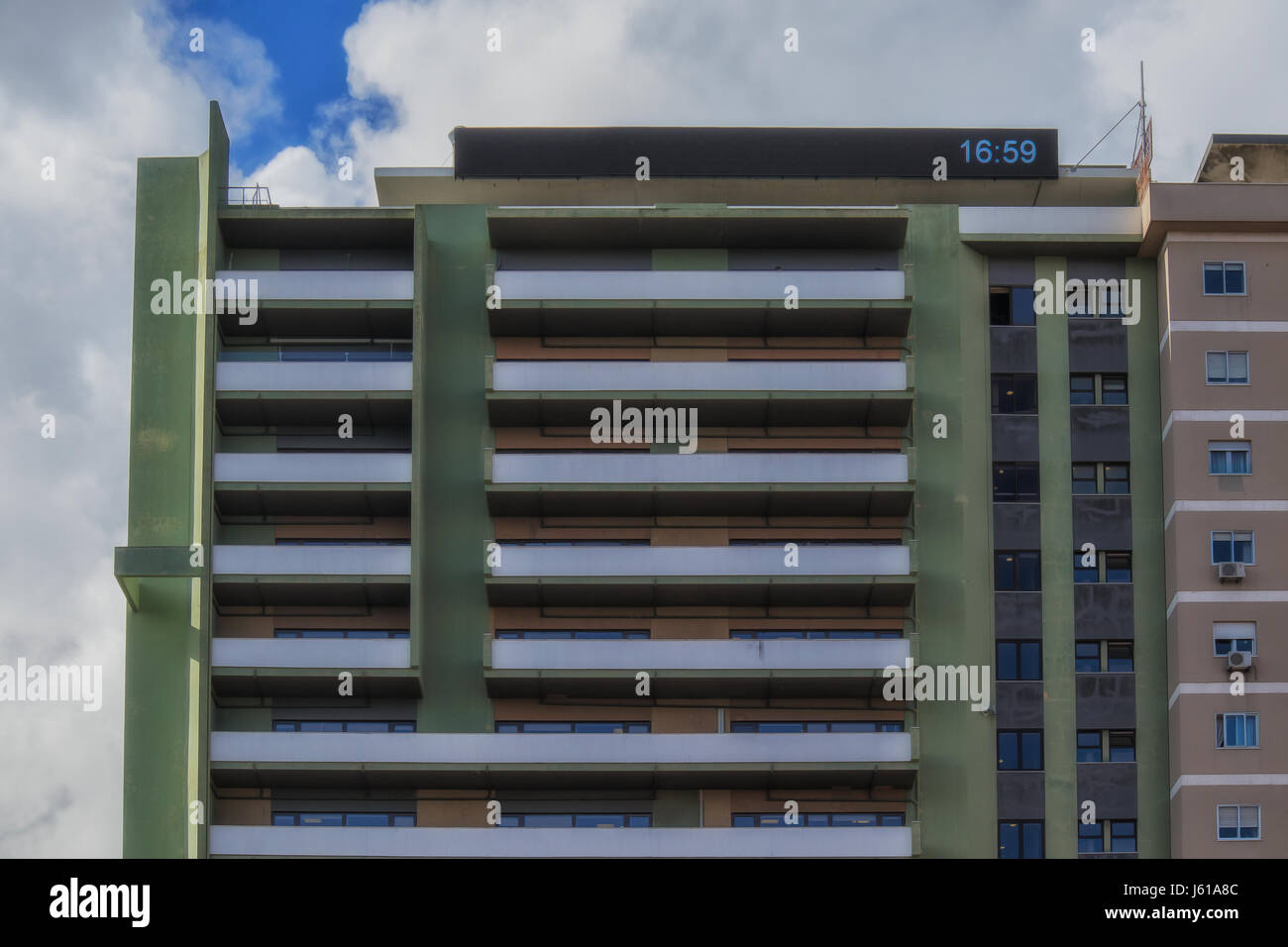 Green building with white balconies and advertising board Stock Photo ...