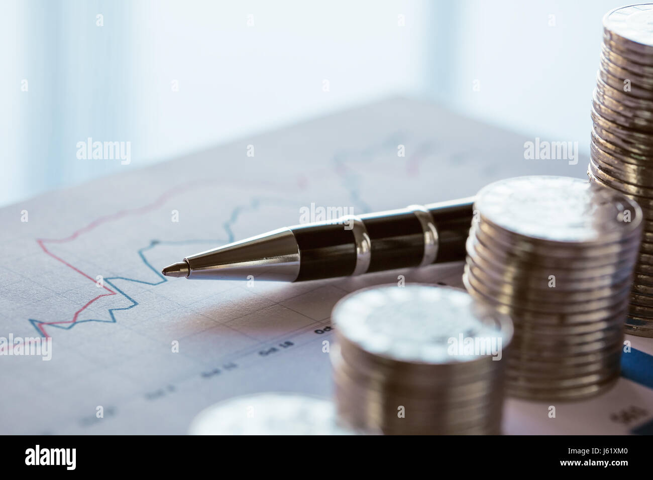 Stack of coin with financial line chart and pen Stock Photo - Alamy