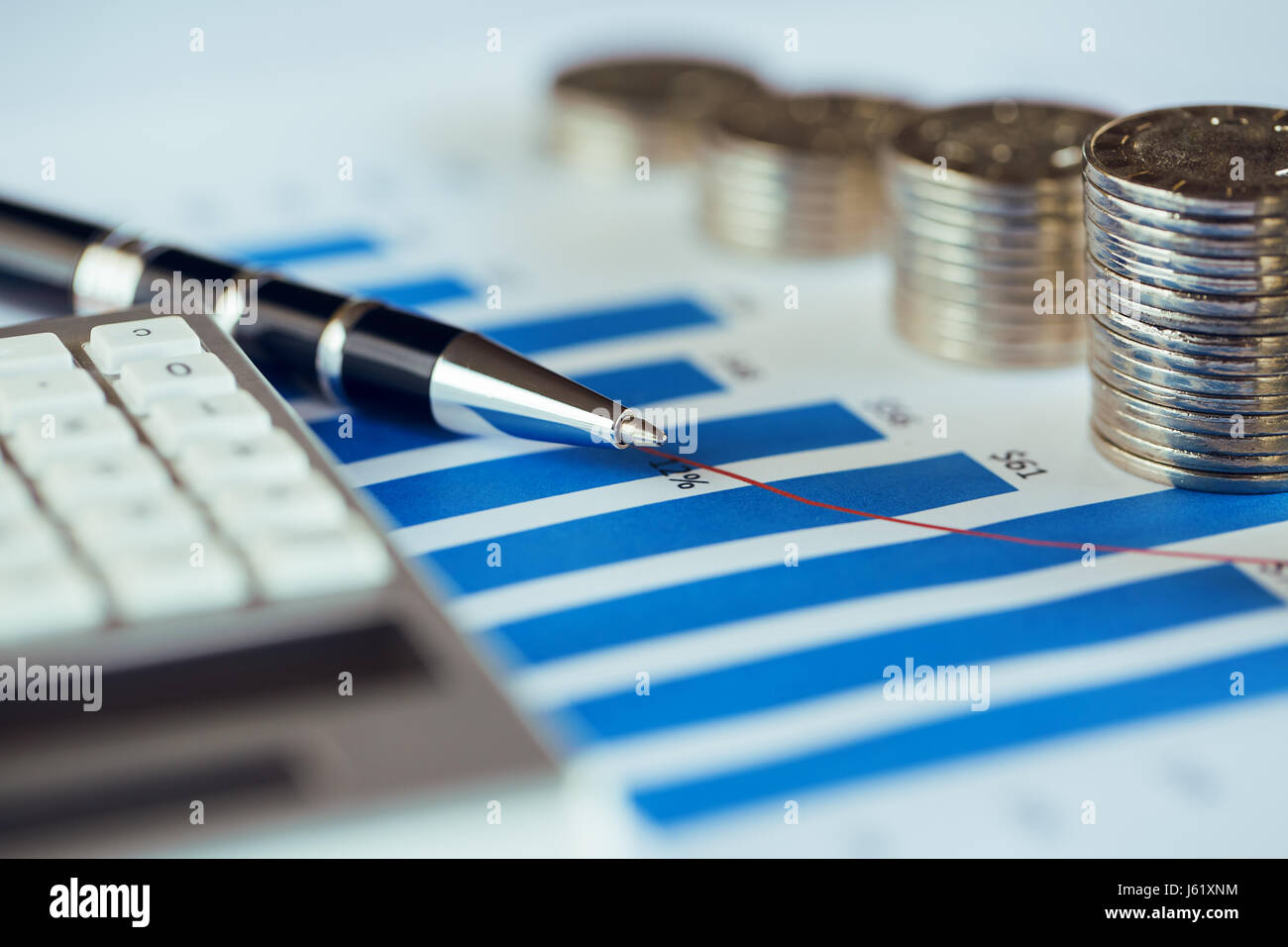 Stack of coins with bar chart, pen and calculator Stock Photo - Alamy