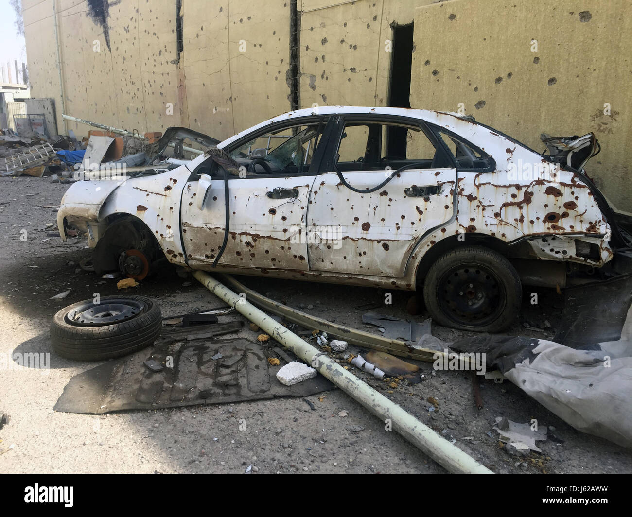 Mosul, Iraq. 09th May, 2017. A shot-up car-wreck sits in the grounds of ...