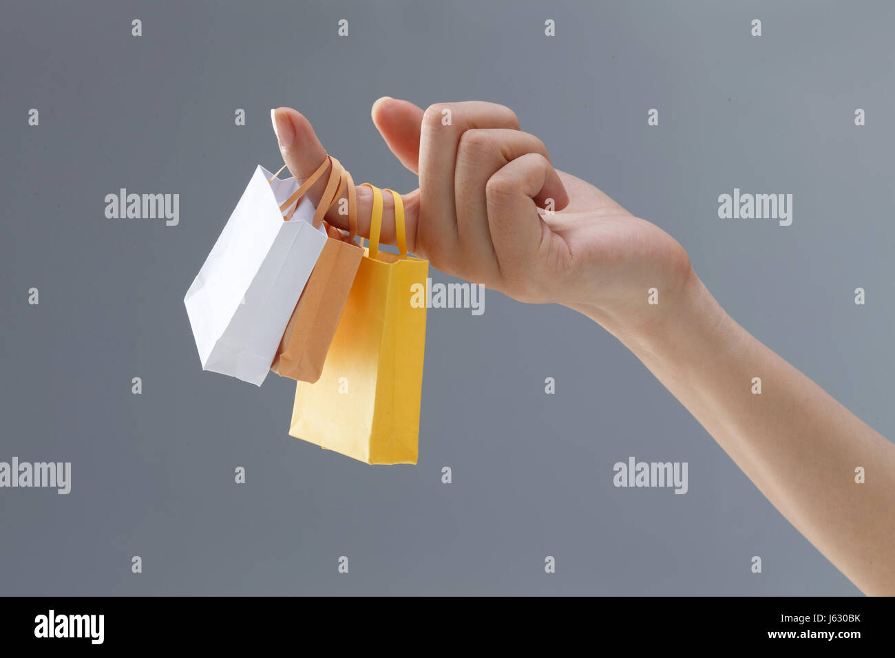 Hand holding a shopping bag Stock Photo - Alamy