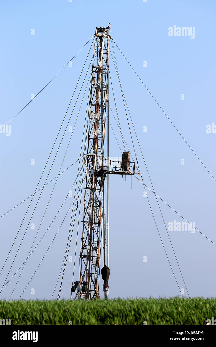 oil drilling rig behind green wheat field Stock Photo - Alamy