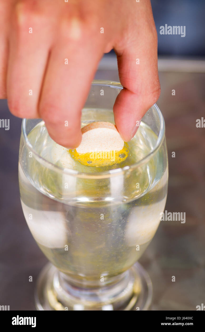 Hand drooping a pill effervescent tablet in a glass of water Stock ...