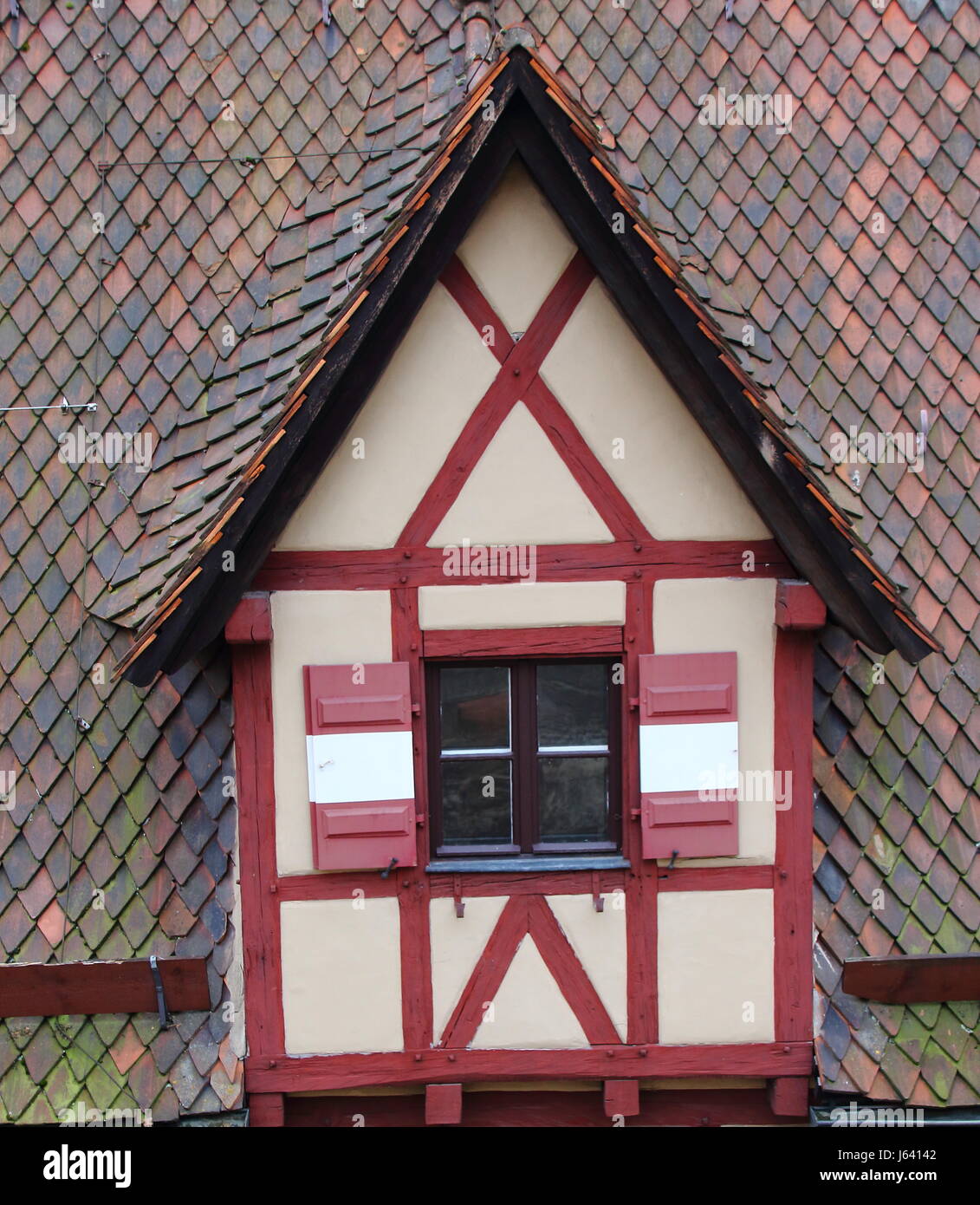 An ornate roof window below patterned tiles Stock Photo - Alamy