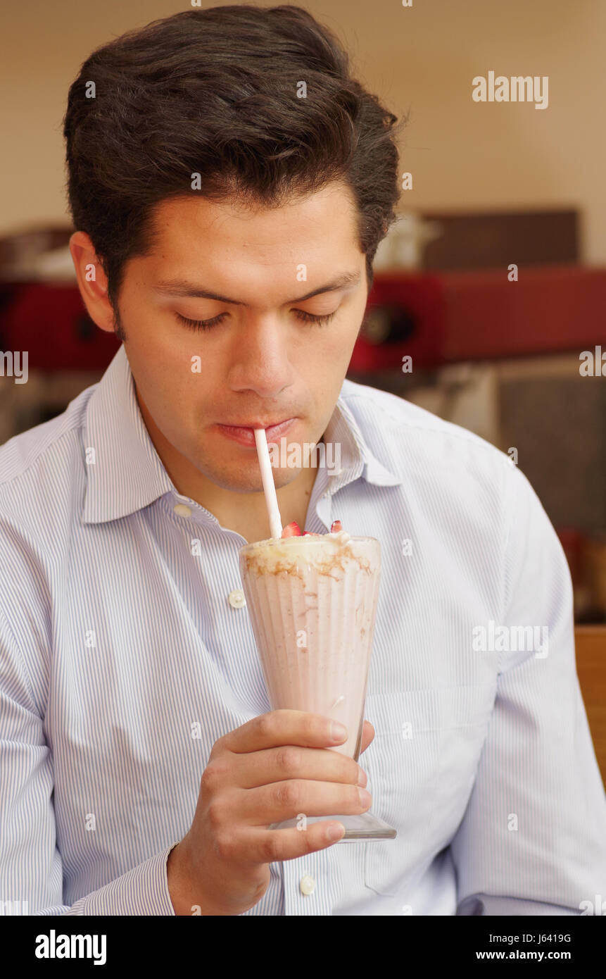 Handsome man having a milkshake with a plastic straw Stock Photo - Alamy