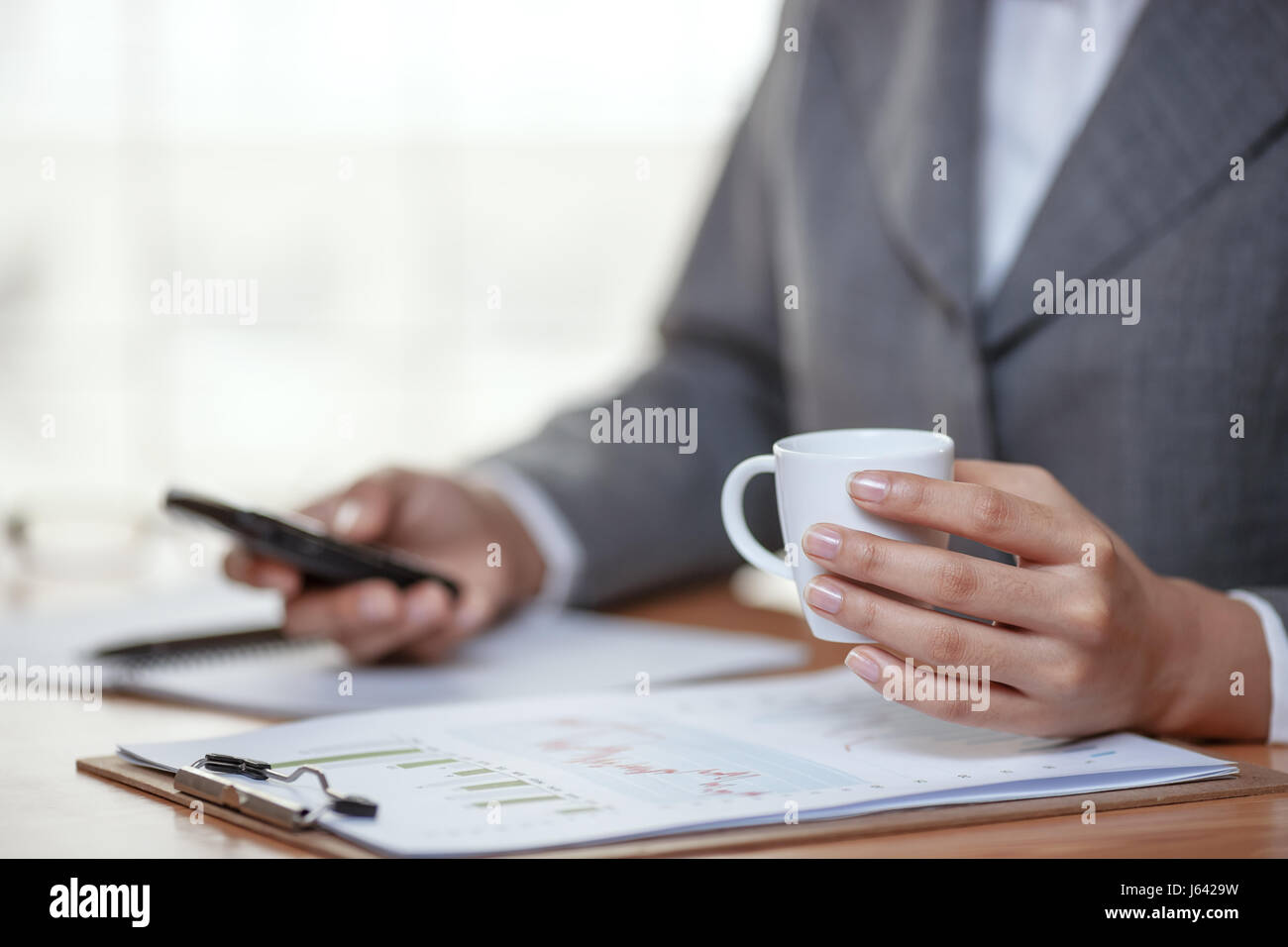Businesswoman making a phone call and drinking coffee Stock Photo - Alamy