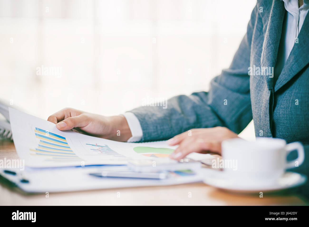 Businesswoman calculating and analyzing business chart Stock Photo - Alamy