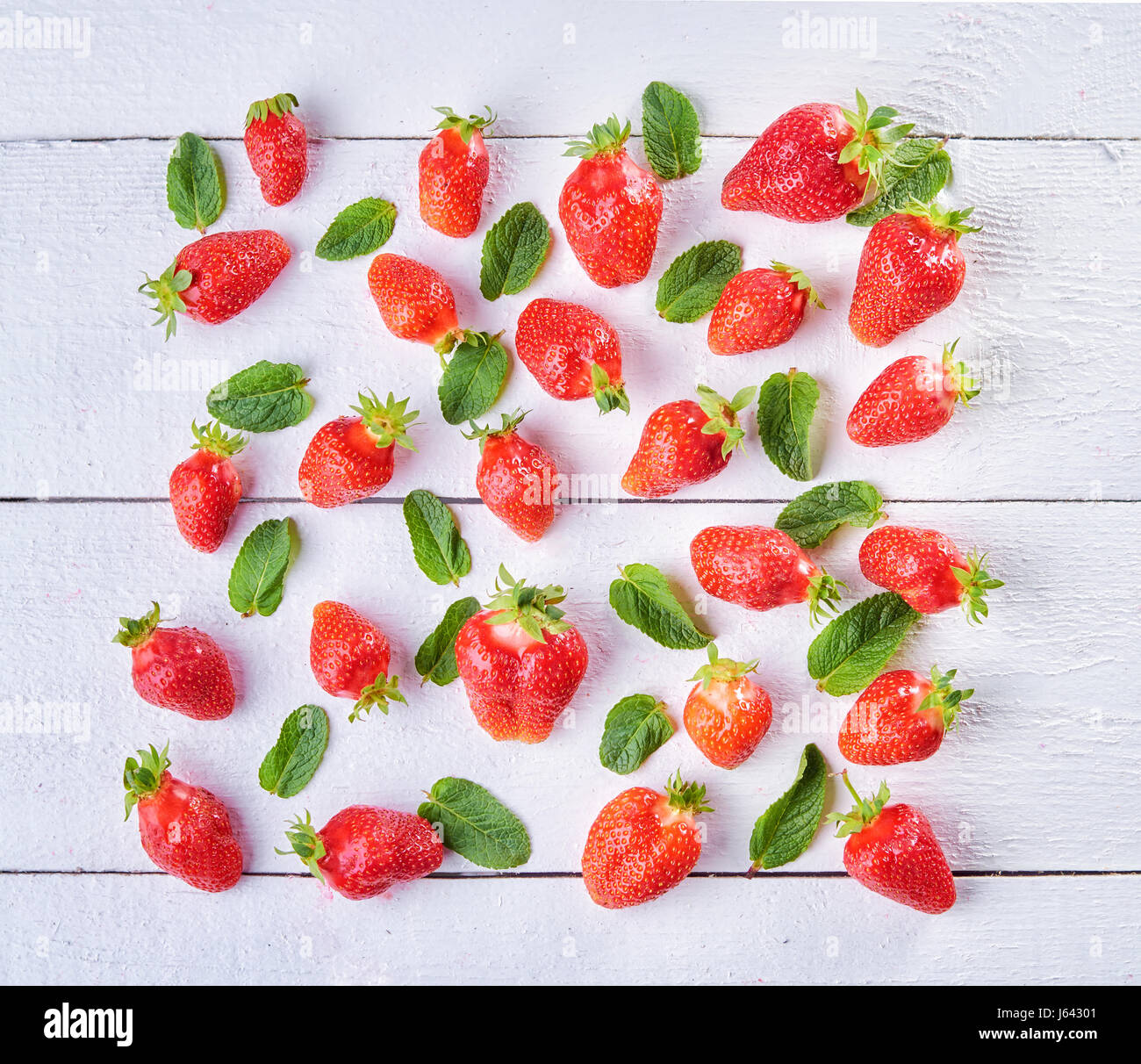 Sweet fruit mix of strawberry and green mint leaves on wintage white ...