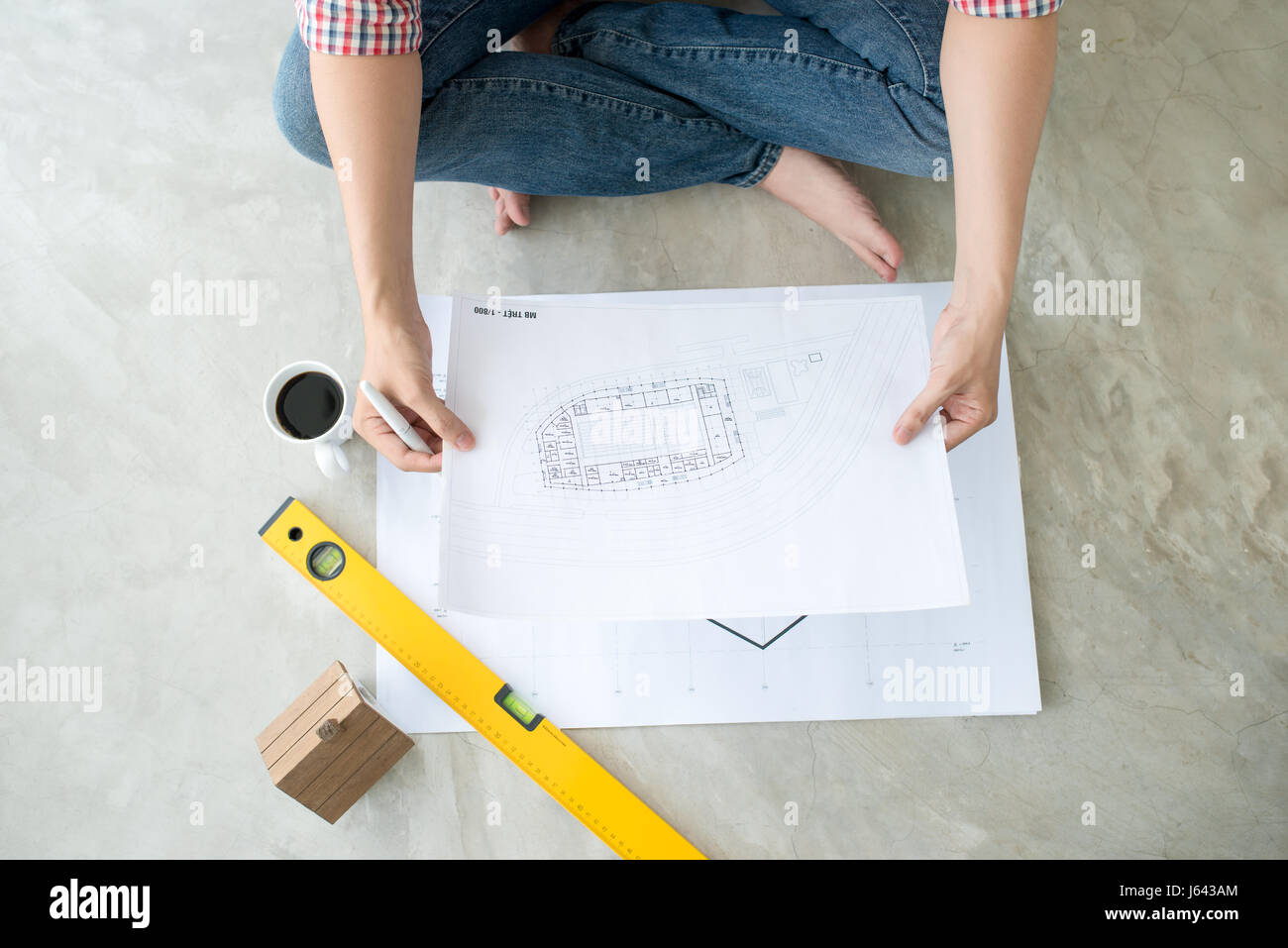 Attractive young asian man looking at house plans Stock Photo - Alamy