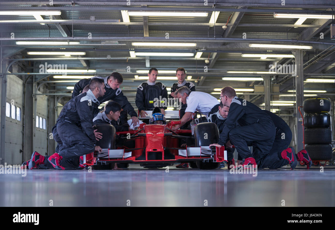 Race car team working on race car in garage Stock Photo - Alamy