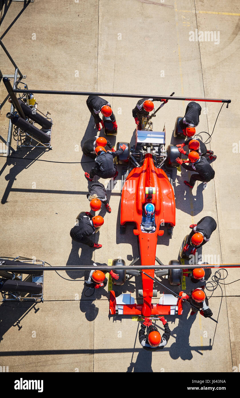 Overhead pit crew working on formula one race car in pit lane Stock ...