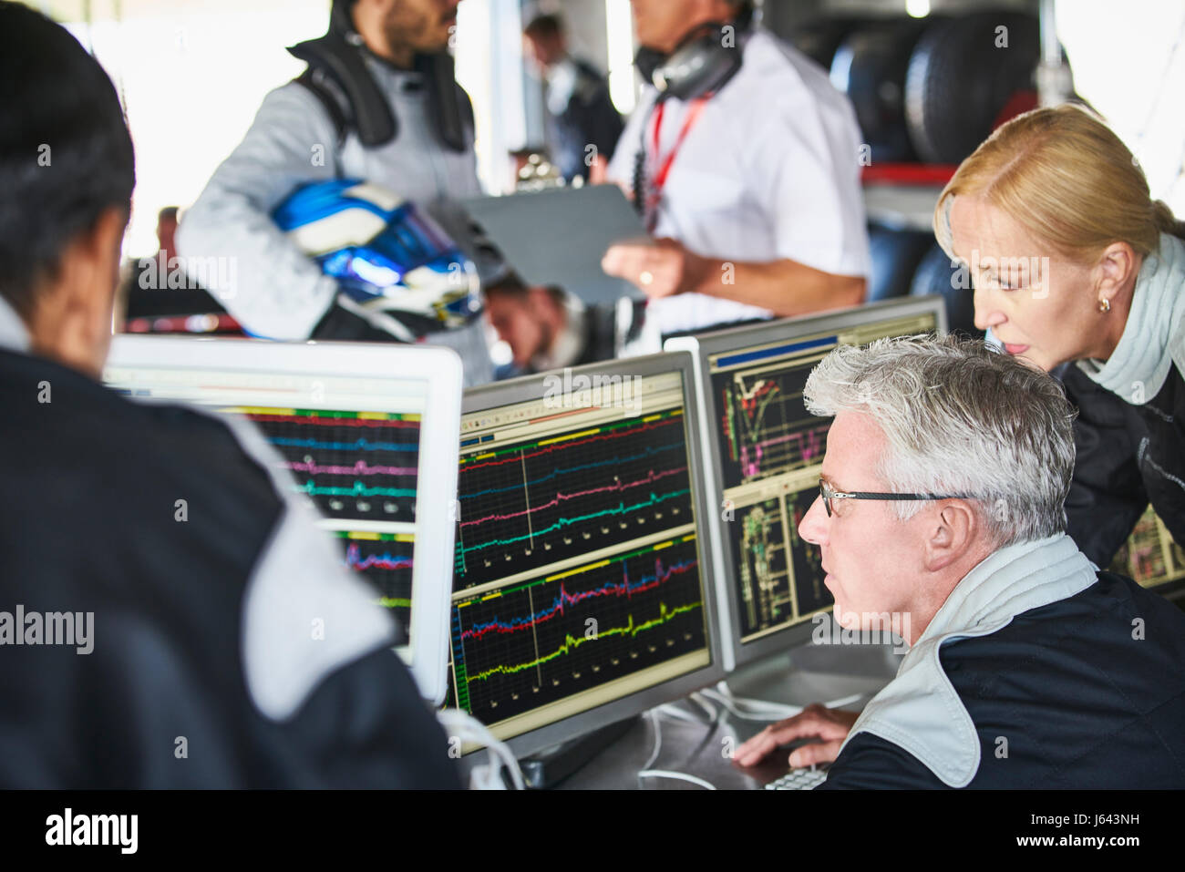 Formula one team reviewing diagnostics telemetry data on computers ...