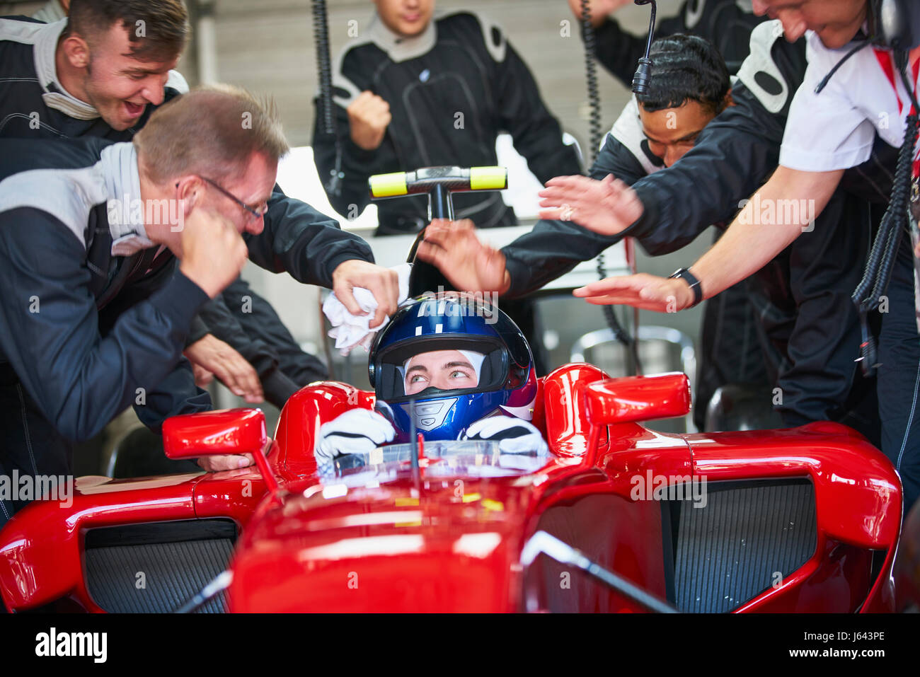 Manager and pit crew congratulating formula one race car driver Stock ...