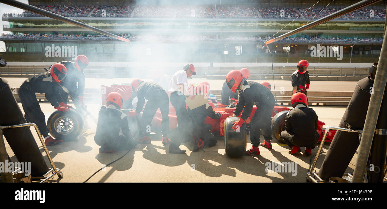 Pit crew replacing tires on formula one race car in pit lane Stock ...