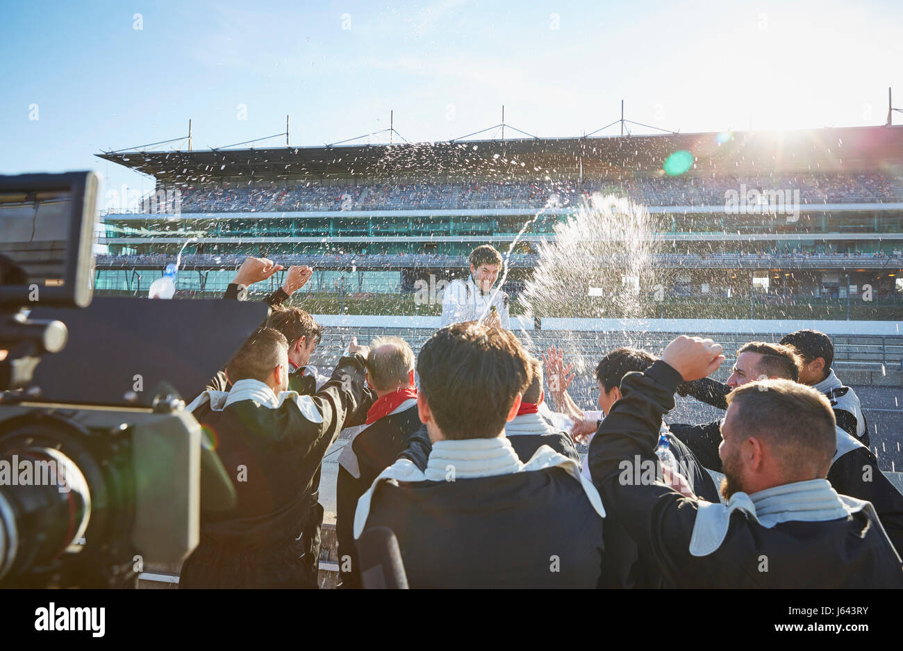 Formula one racing team spraying champagne on driver, celebrating ...