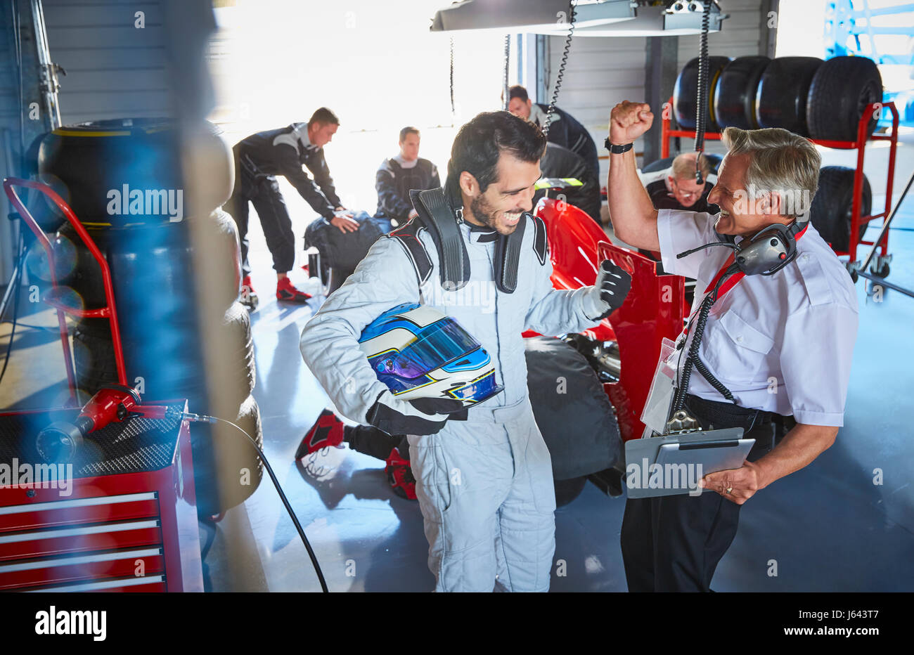 Driver and formula one race car driver cheering, celebrating victory in ...