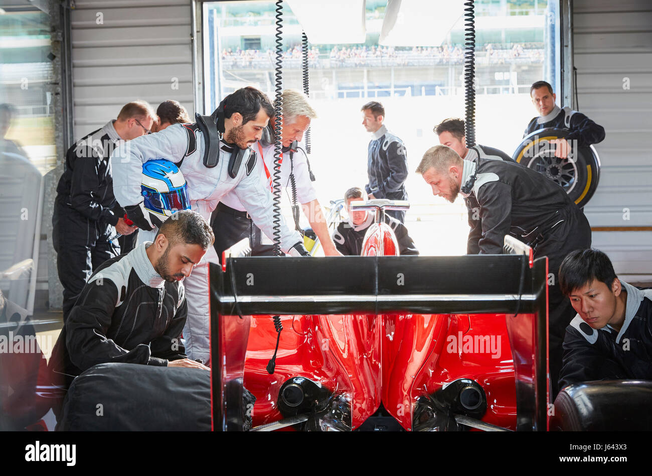 Pit crew preparing formula one race car in repair garage Stock Photo ...