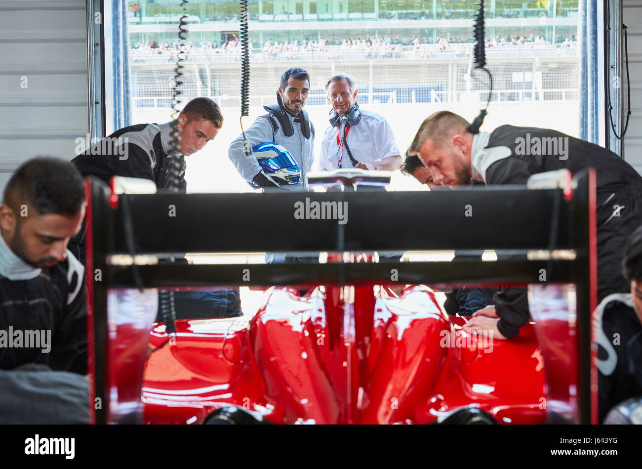 Pit crew working on formula one race car in repair garage Stock Photo ...