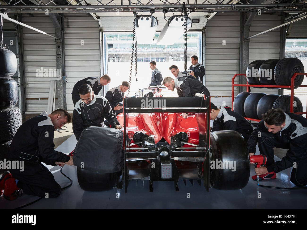 Pit crew working on formula one race car in repair garage Stock Photo - Alamy