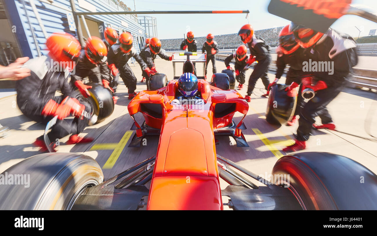 Pit crew replacing tires on formula one race car in pit lane Stock ...