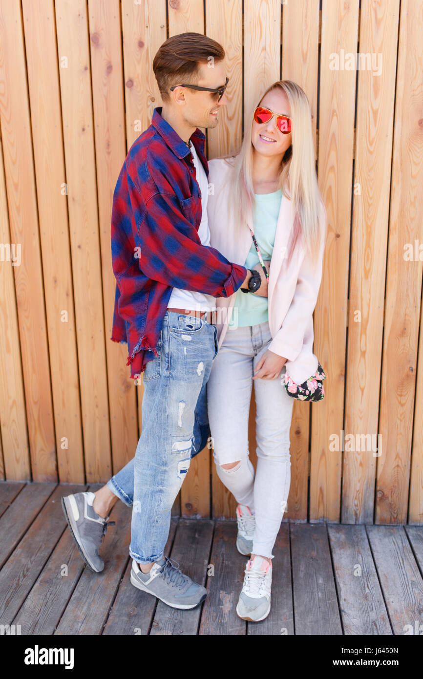 Young couple hugging against wall Stock Photo - Alamy