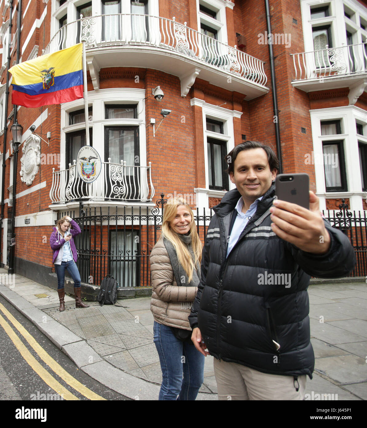 Tourists take a selfie outside at the Ecuadorian embassy in London ...