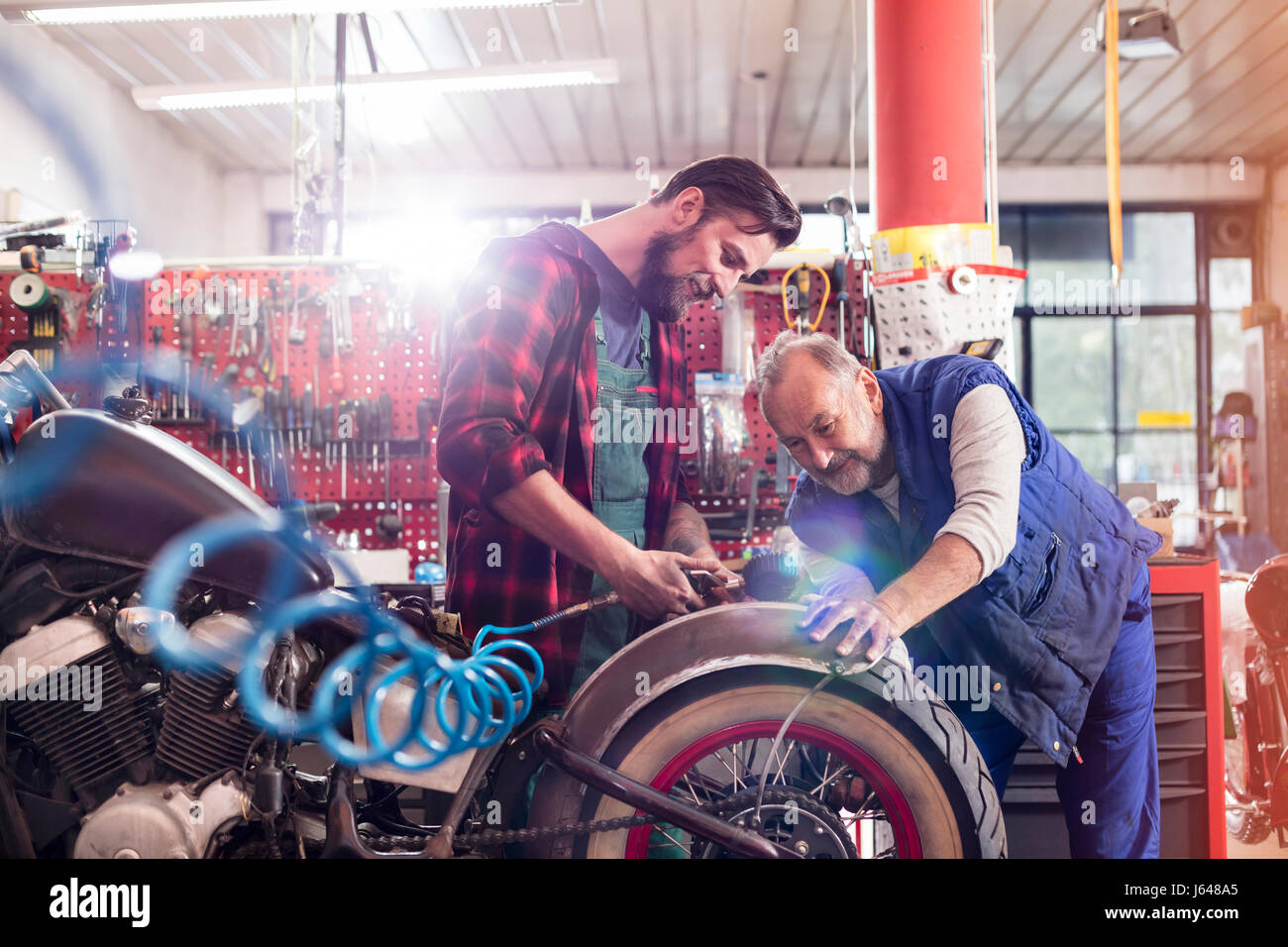Mechanics in garage workshop discussing hi-res stock photography and ...