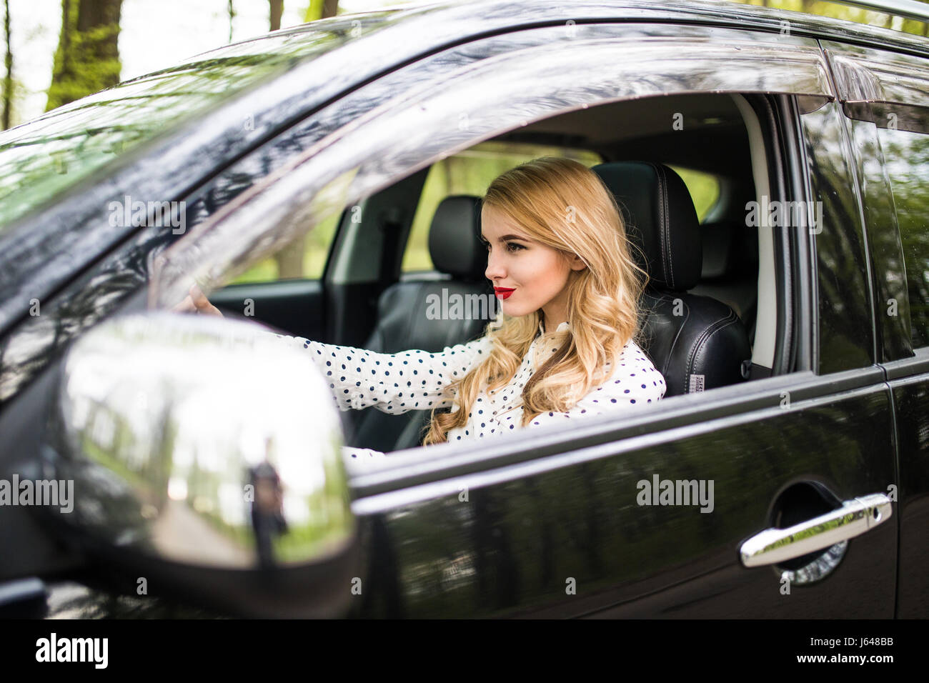 Young woman driving her car on road Stock Photo - Alamy
