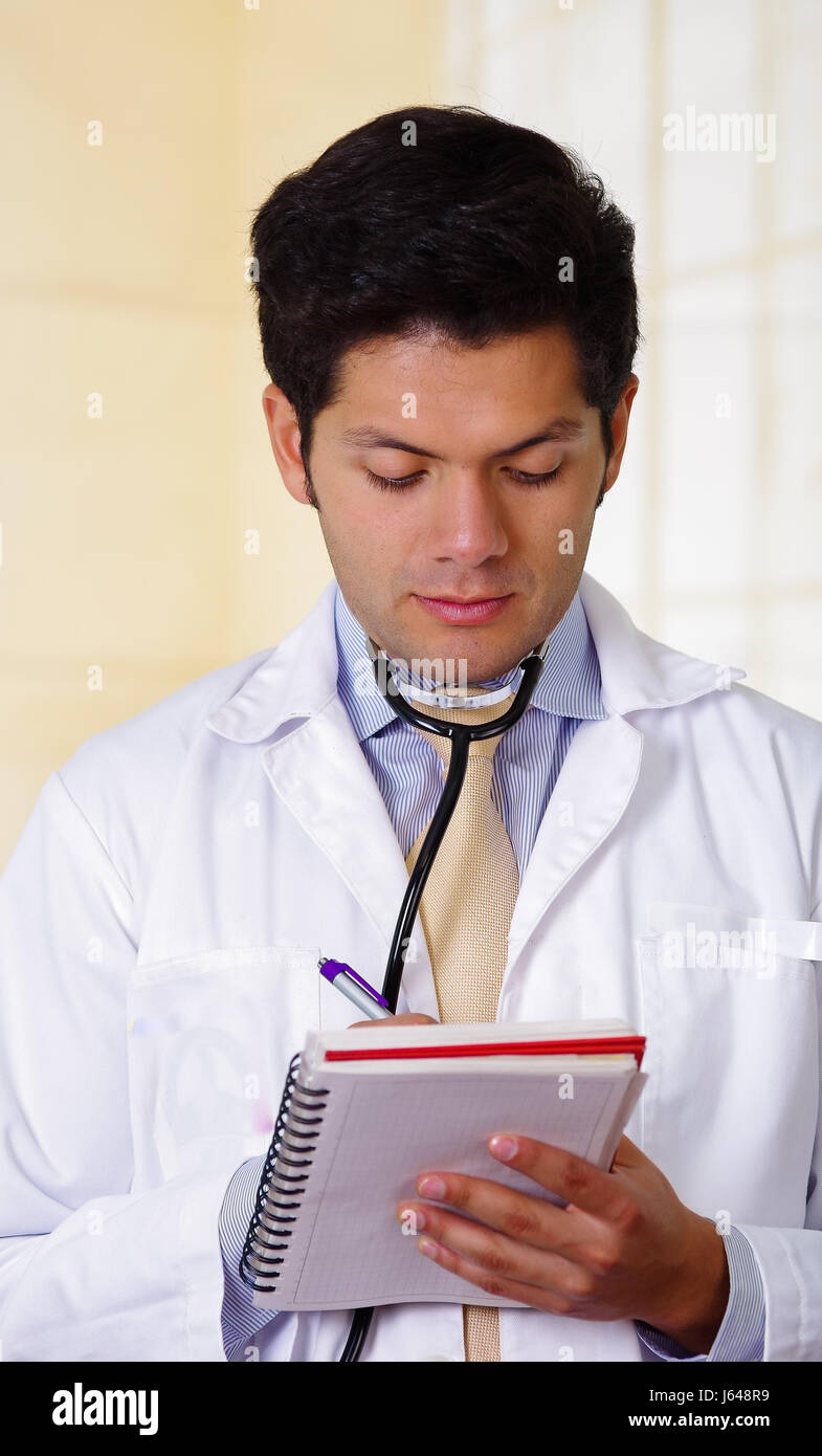 Handsome doctor with an Stethoscope holding from his neck, writing on ...