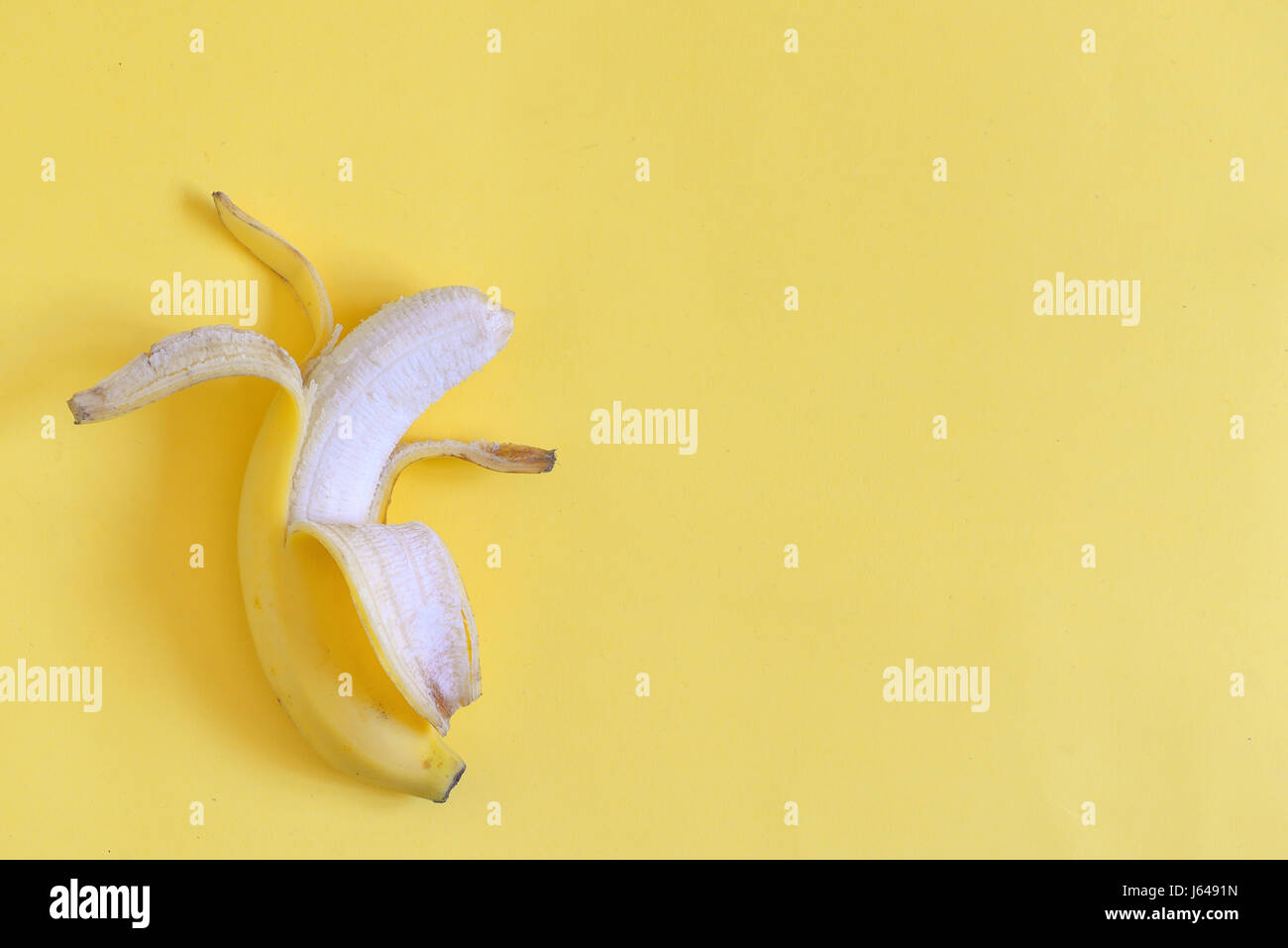 Ripe open banana on yellow background Stock Photo - Alamy
