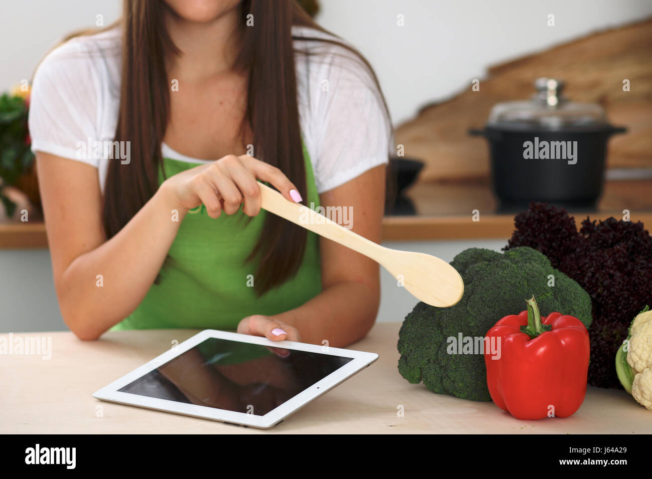 Young woman is going to cook healthy meal from vegetables. Close up of ...