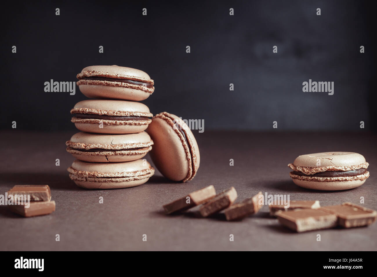 Stack of Chocolate pastel brown Macarons or Macaroons over dark ...
