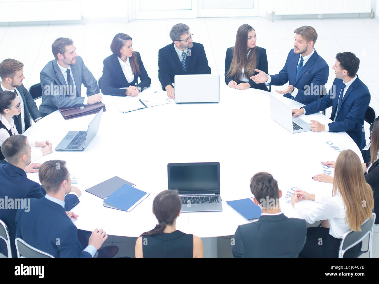 business team gathered round the table and listens to the report of the ...