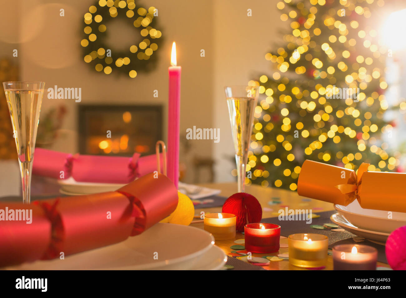 Candles, champagne and Christmas crackers on table Stock Photo - Alamy