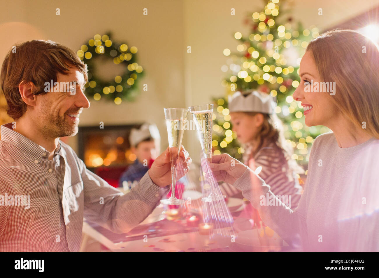 Couple toasting champagne flutes at Christmas dinner table Stock Photo ...
