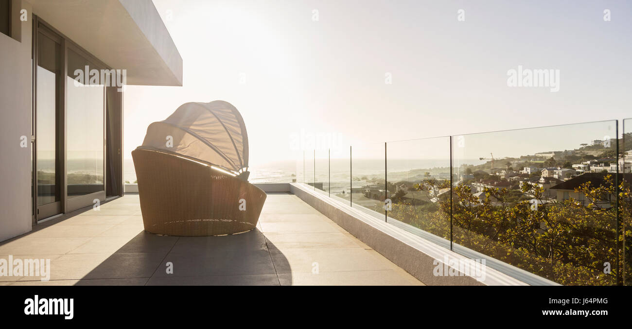 Covered lounge chair on sunny luxury sunset balcony Stock Photo - Alamy