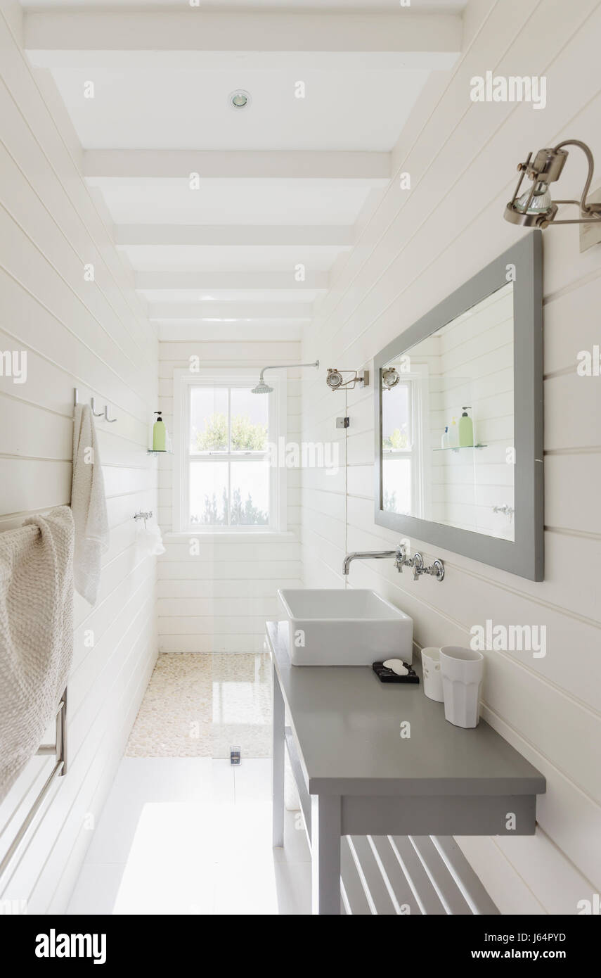 Long, sunny white modern luxury bathroom Stock Photo - Alamy