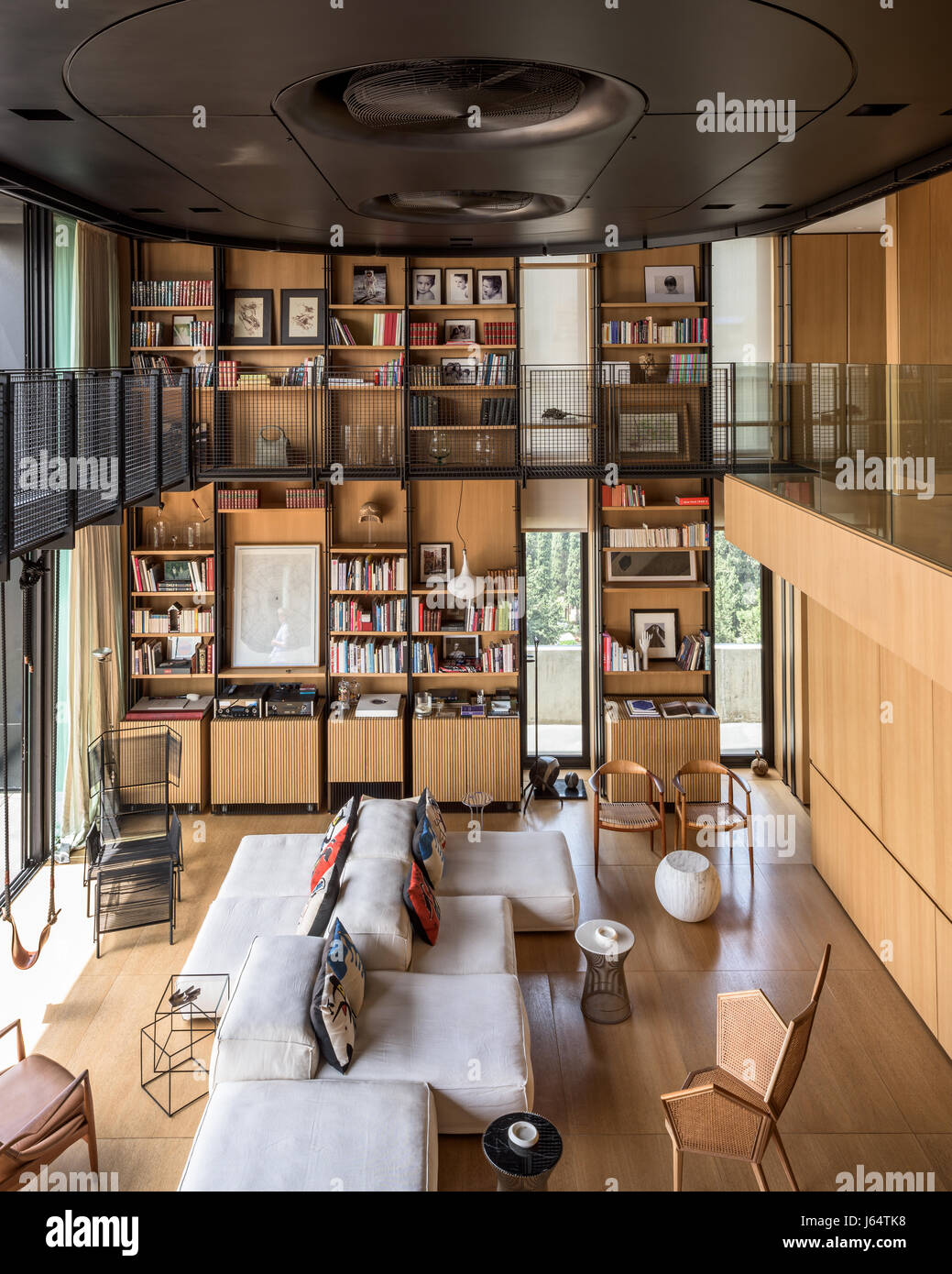 Spacious double-height living area with tall narrow windows. The ...
