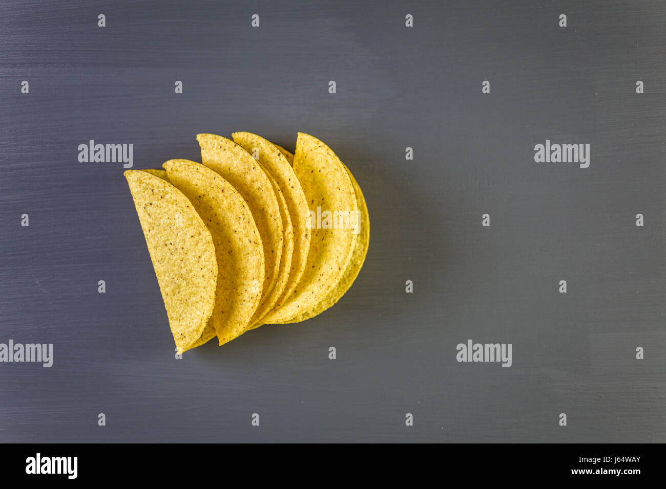 Yellow corn taco shells on a gray background Stock Photo - Alamy