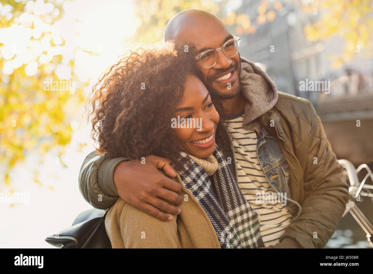 Smiling, affectionate couple hugging and looking away Stock Photo - Alamy