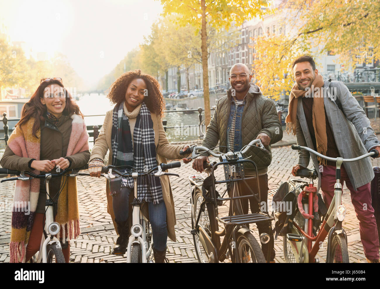 Portrait smiling friends bike riding on urban autumn street, Amsterdam ...