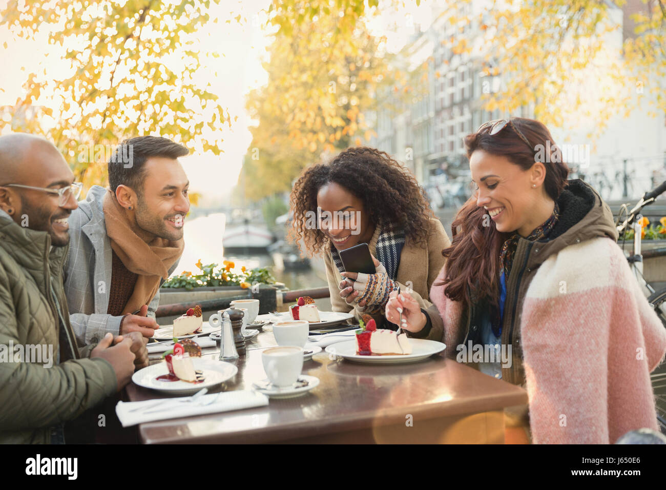Friends eating cheesecake dessert at autumn sidewalk cafe Stock Photo ...