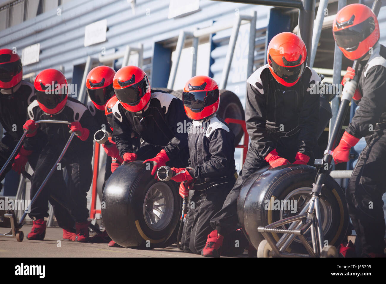 Pit crew ready with tires in formula one pit lane Stock Photo - Alamy