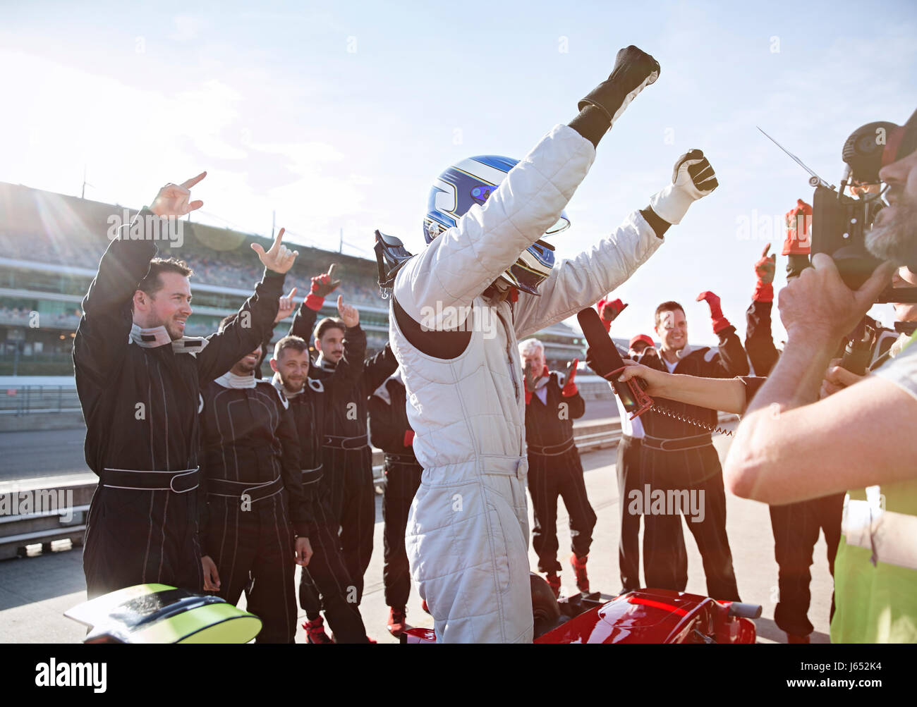 Formula one racing team and driver cheering, celebrating victory on ...