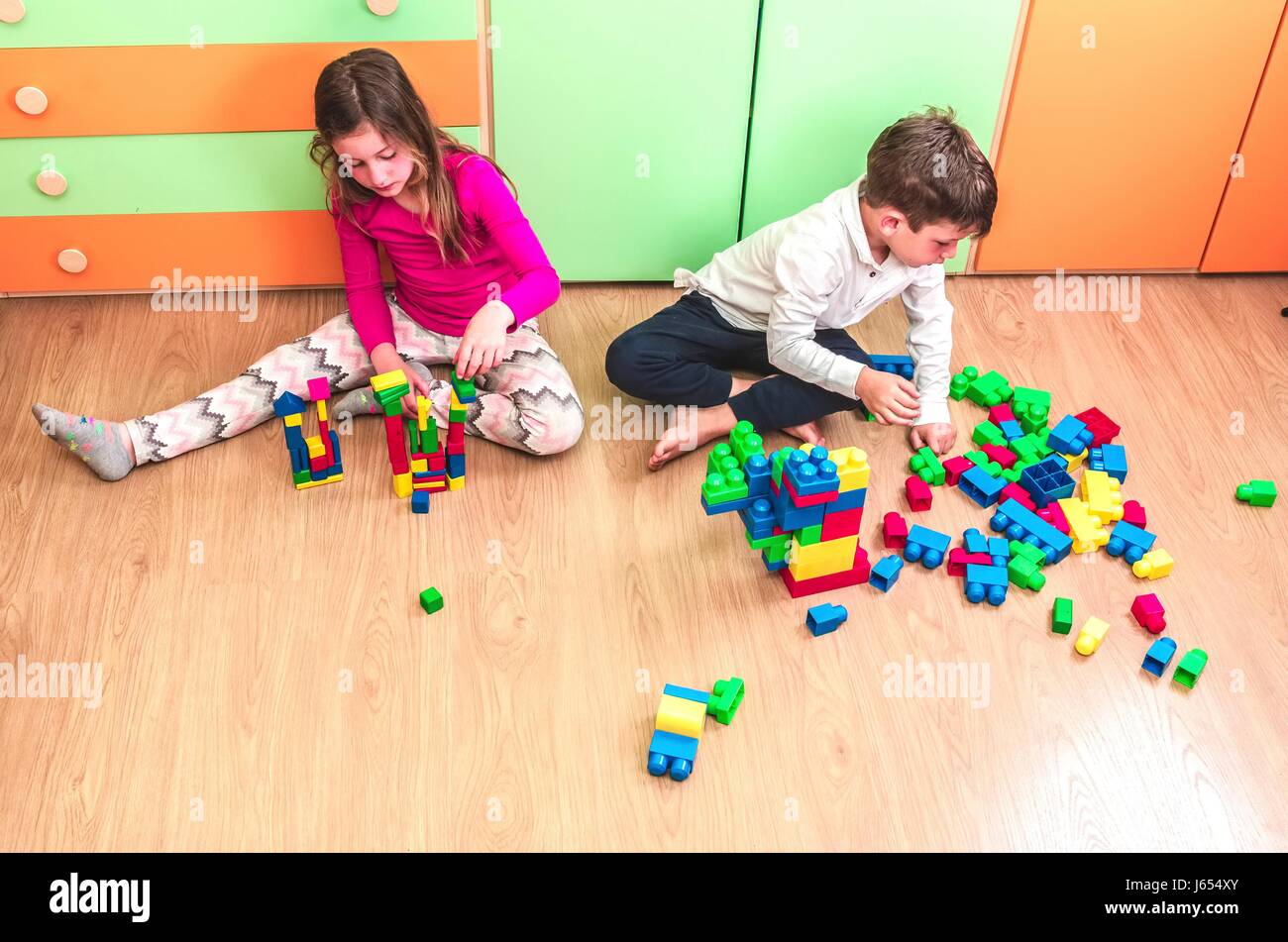 Children playing with construction toy blocks on floor of house Stock ...