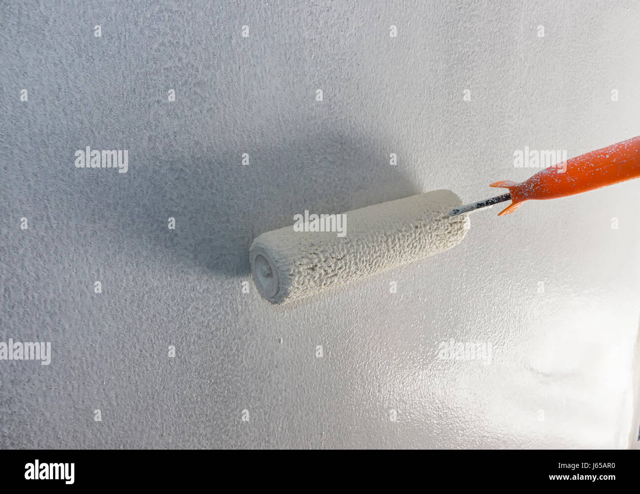 Panting white color on paster wall with paddle roller Stock Photo - Alamy