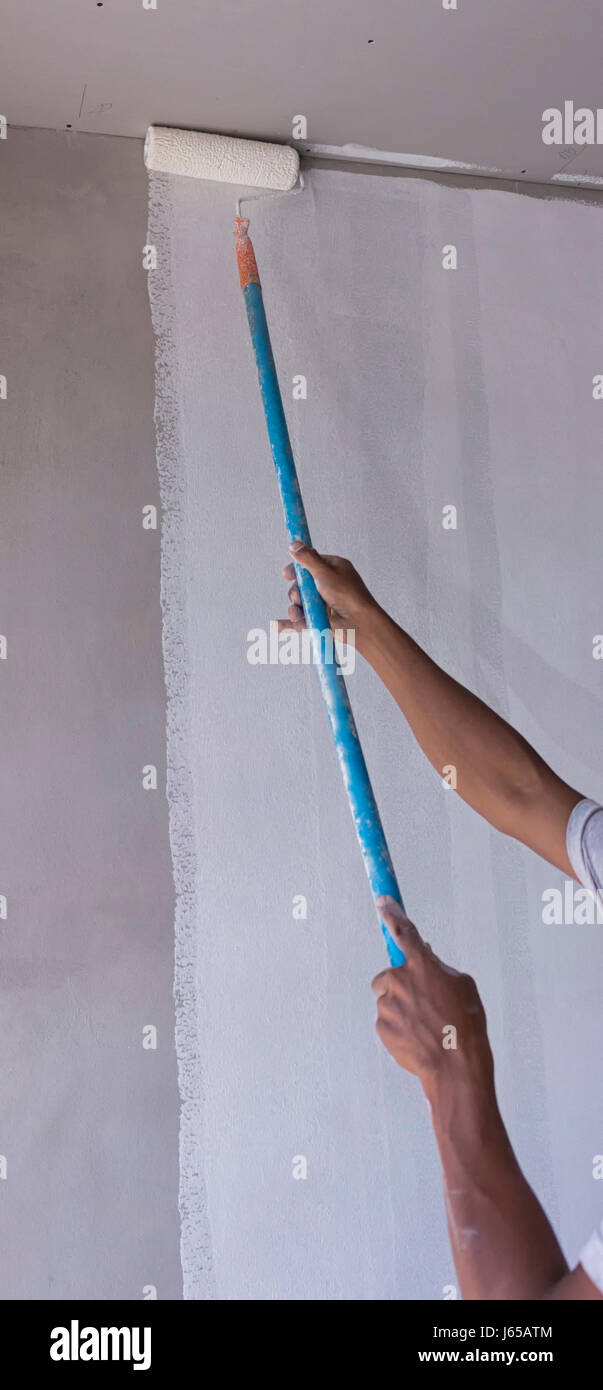 Painting white color on paster wall with paddle roller Stock Photo - Alamy
