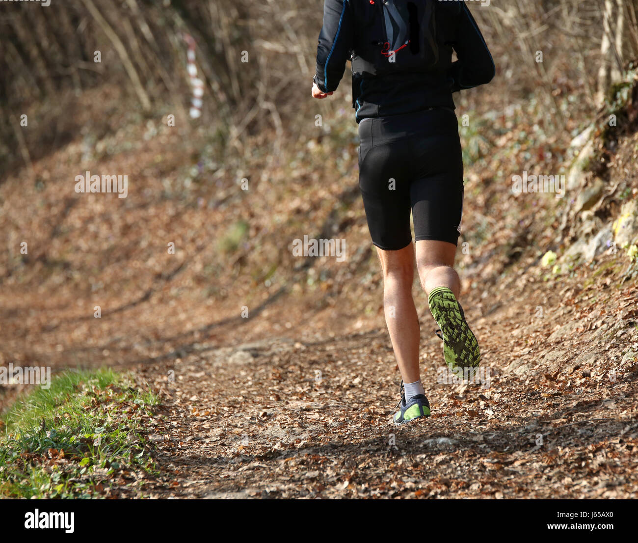 Leg of athlete runner from behind during racing on the mountain trail ...