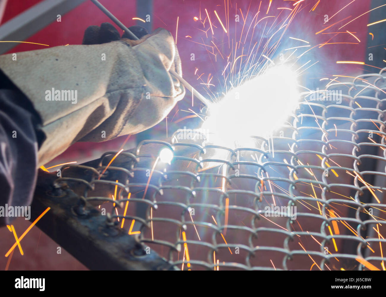 operator is welding a net with flash light and smoke Stock Photo - Alamy