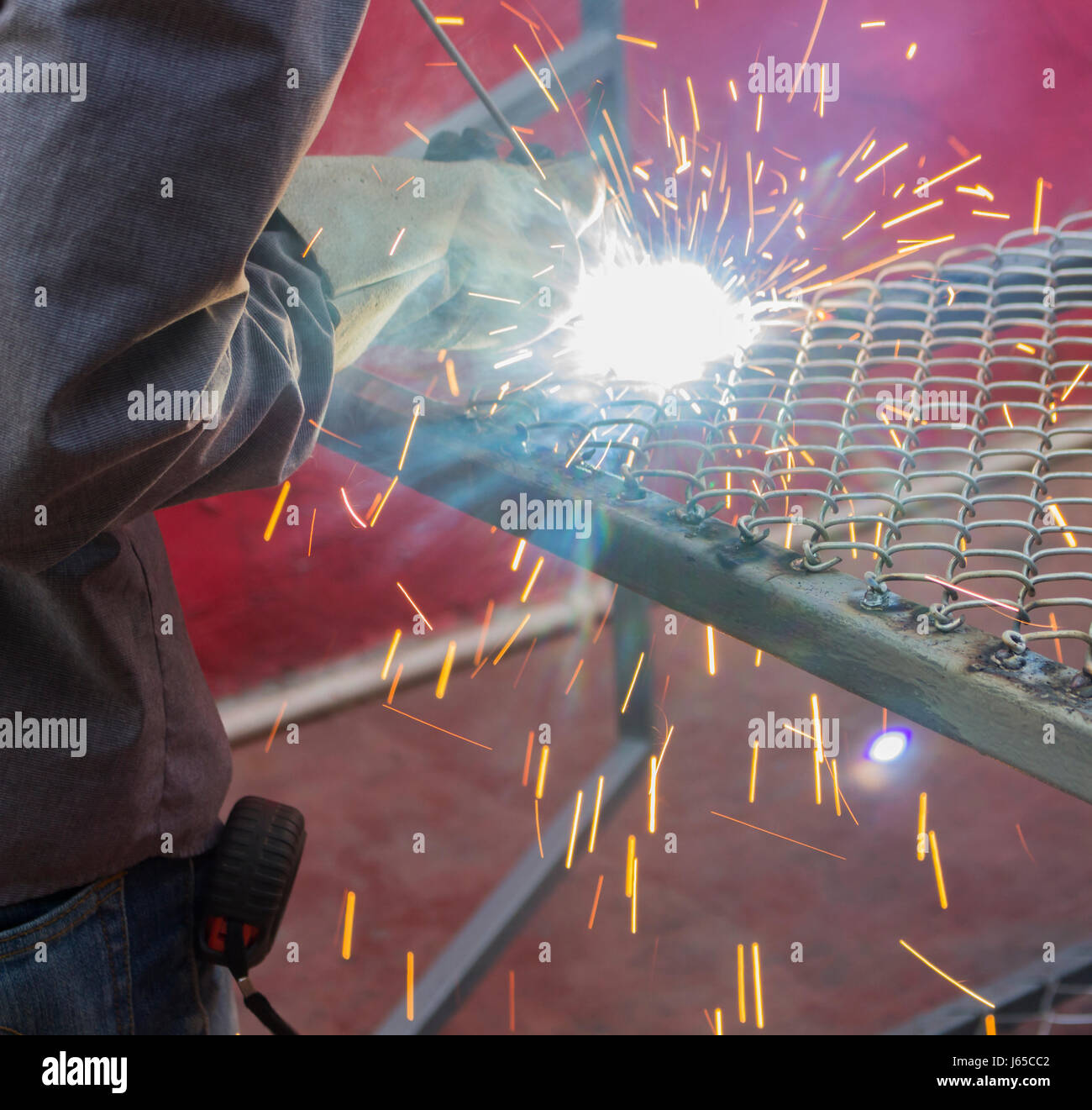 operator is welding a net with flash light and smoke Stock Photo - Alamy